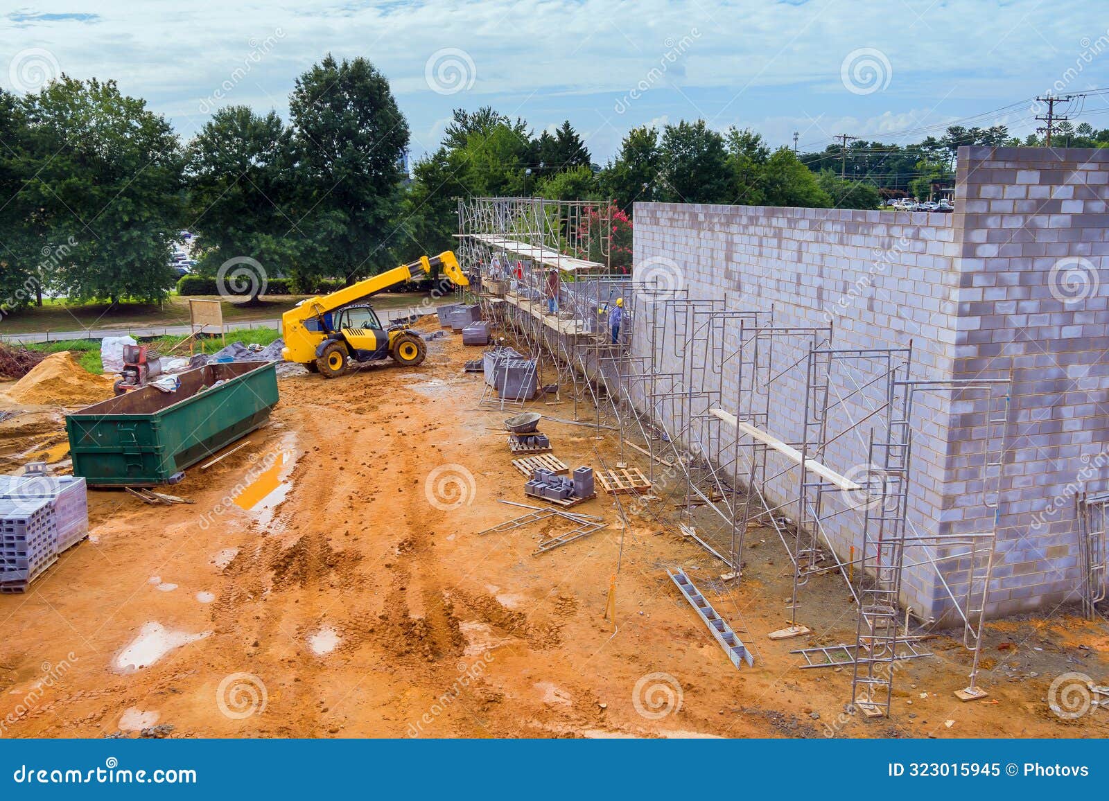 Masonry Worker Standing on Scaffolding Makes a Concrete Wall Using ...