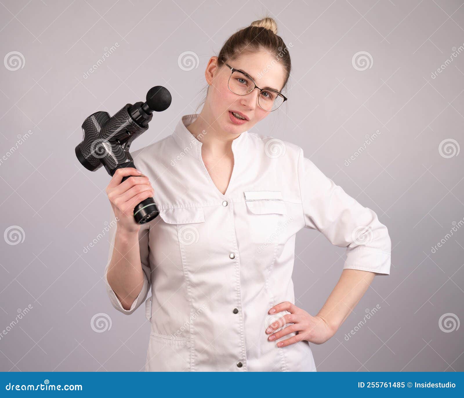 The Masseur Doctor Holds a Masseur Gun on a White Background. Stock ...