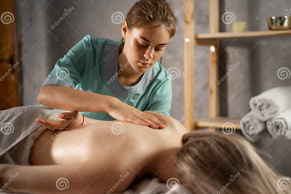 Masseur Massaging Shoulder Of Young Woman Female Patient Getting