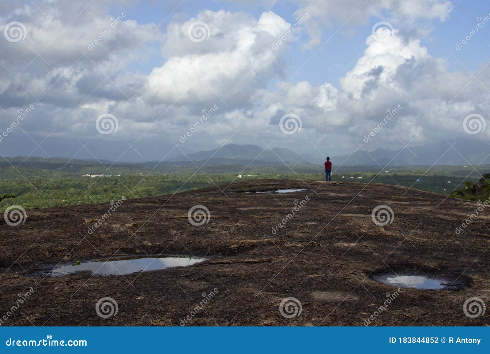 A Massive Rock Surface, Dramatic Sky and a Boy Standing Edge of the ...