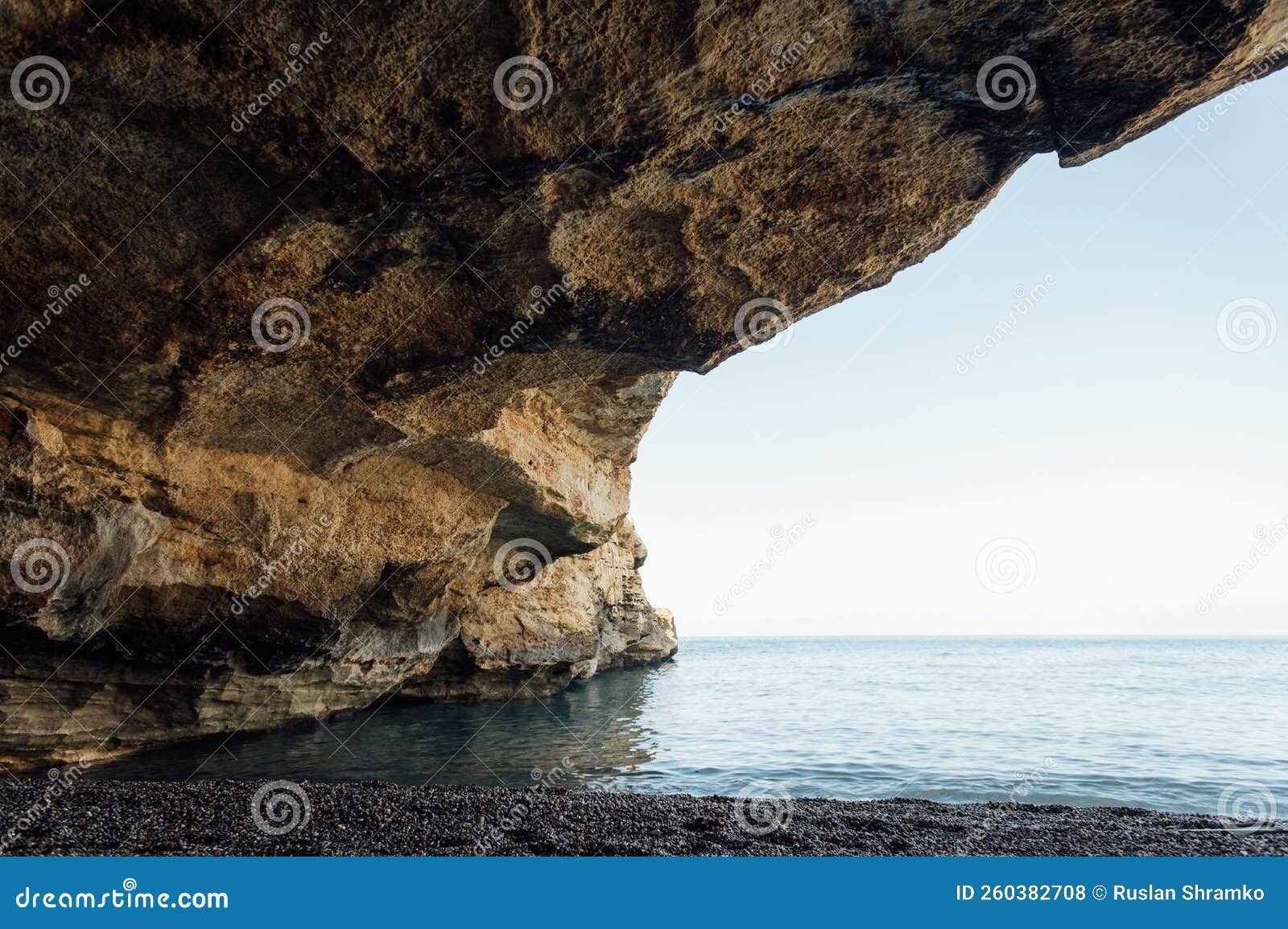 Massive Rocks Sink into the Water on a Pebble Beach Stock Photo - Image ...