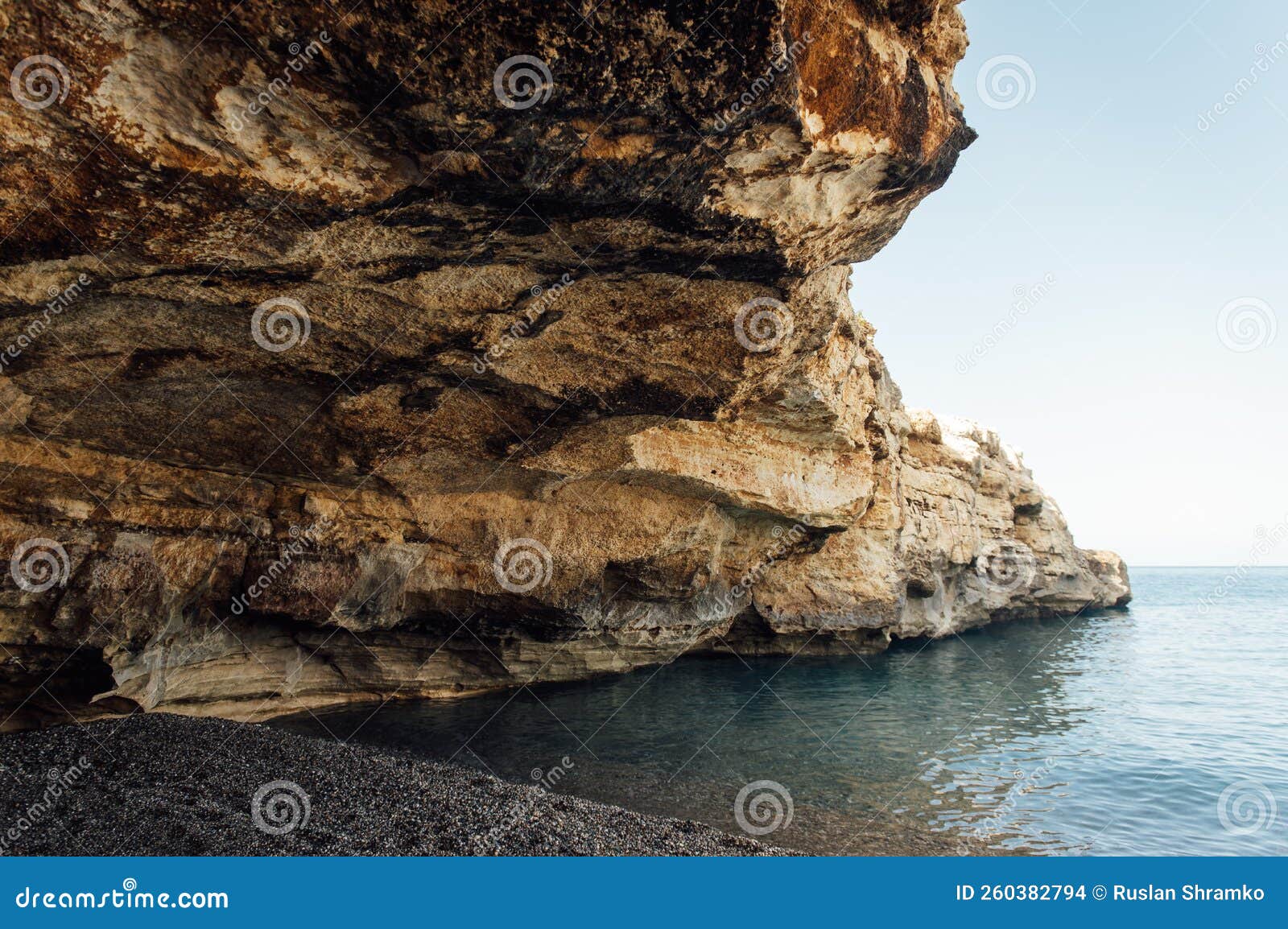 Massive Rocks Sink into the Water on a Pebble Beach Stock Photo - Image ...