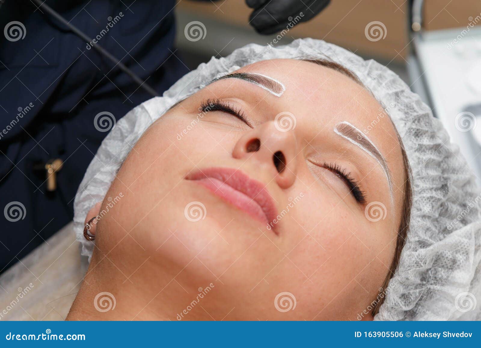 The Master Applies an Eyebrow Mask To the Client Using a Tattoo Machine ...