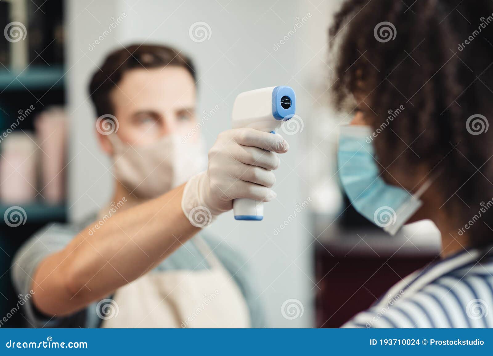 Master Checking Client with Touchless Infrared Thermometer Stock Photo ...