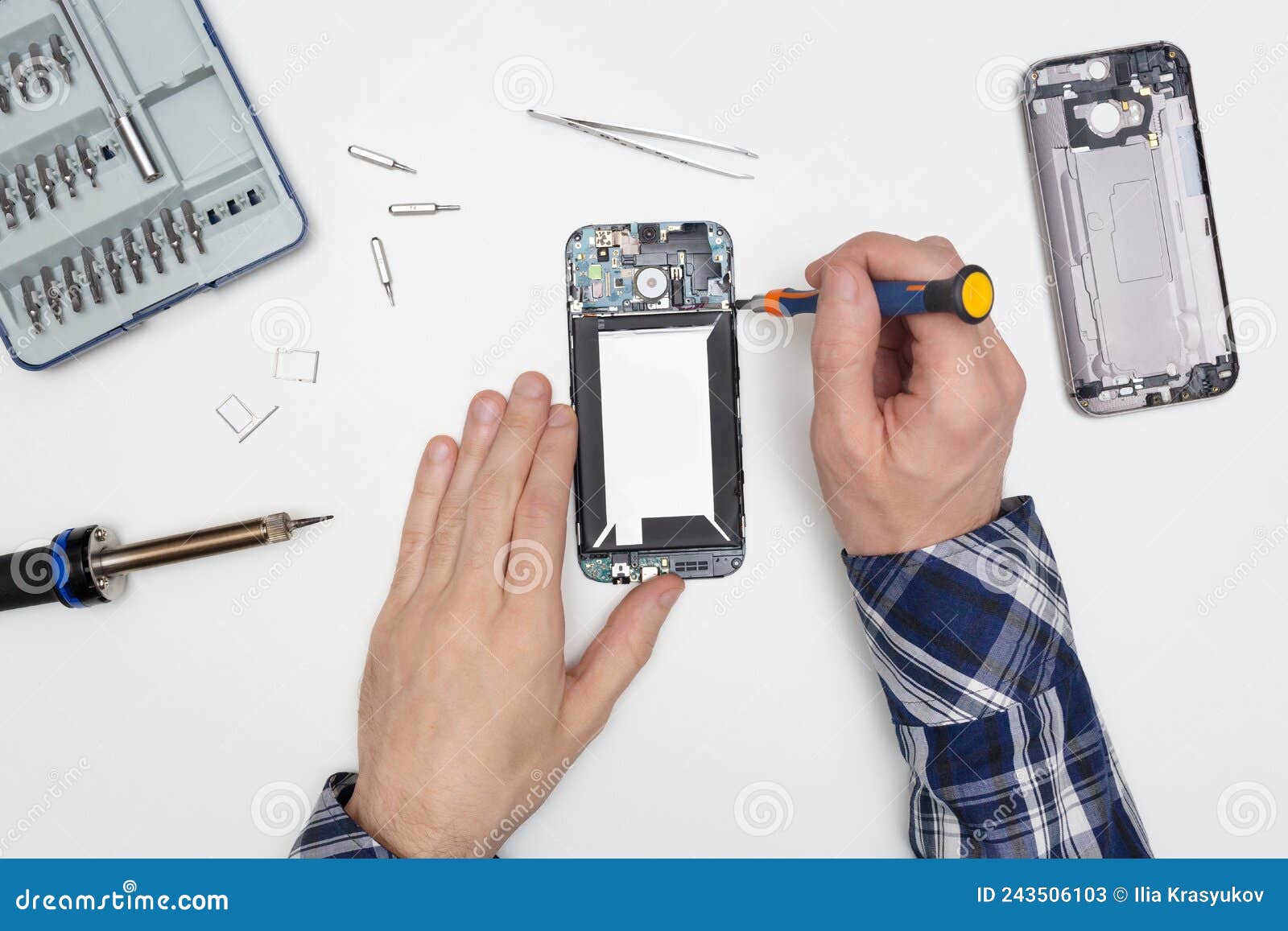 Master Disassembles a Broken Mobile Phone with a Screwdriver. Man ...
