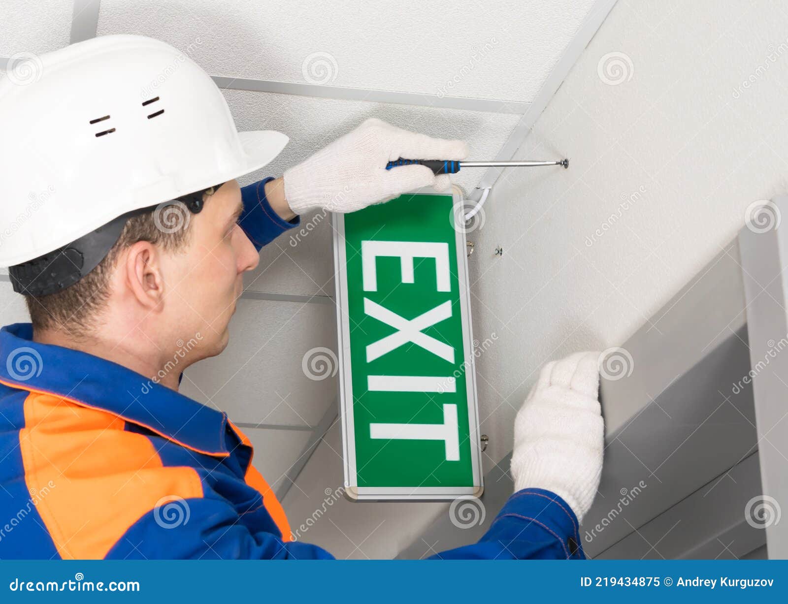 The Master Screws the Emergency Exit Lighting with a Screwdriver Stock ...