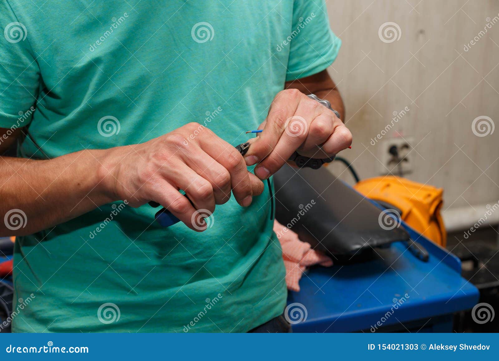 The Master in the Service Removes Insulation from the Wire. Stripping a ...