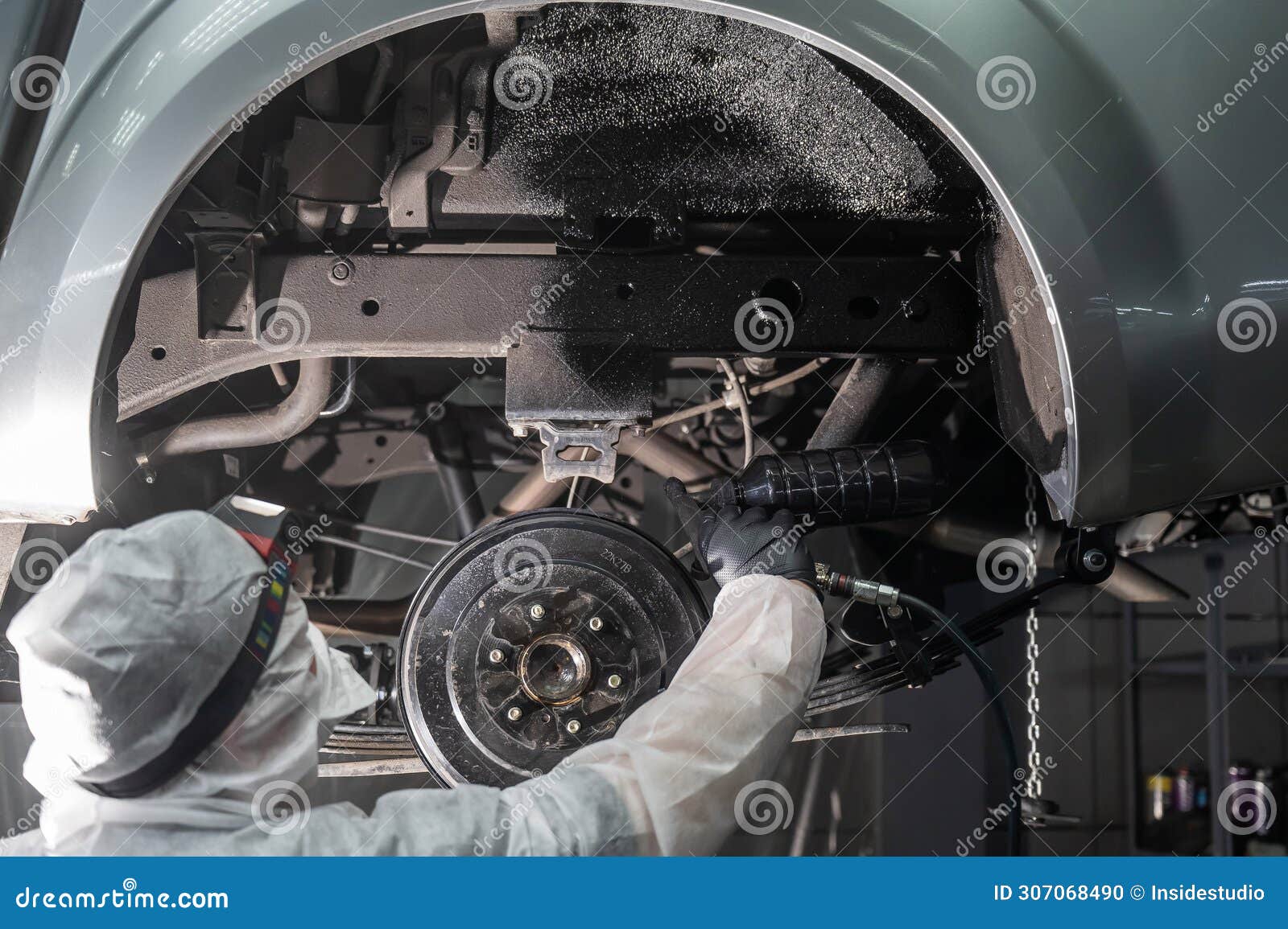 The Master Sprays an Anti-corrosion Compound on the Bottom of the Car ...