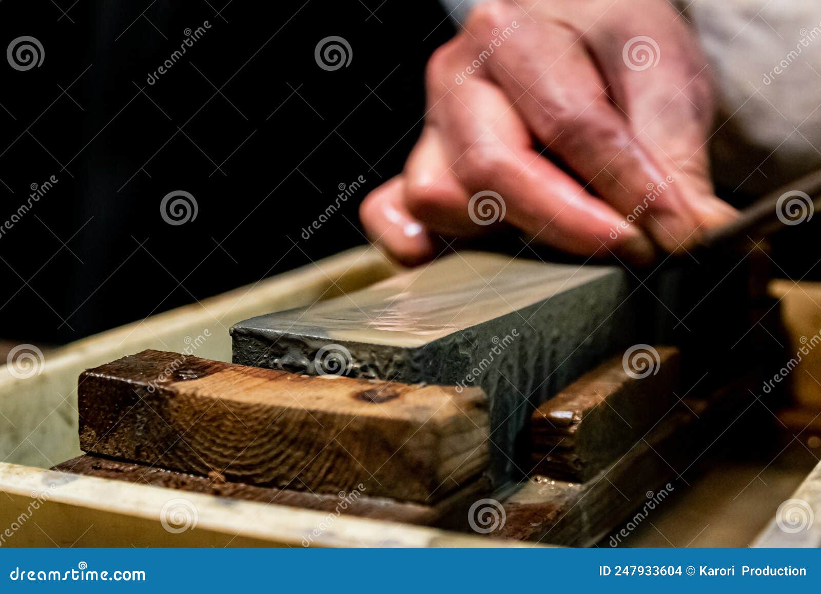 Master Swordsmith is Sharpening Knife on Grindstone with Water Stock ...