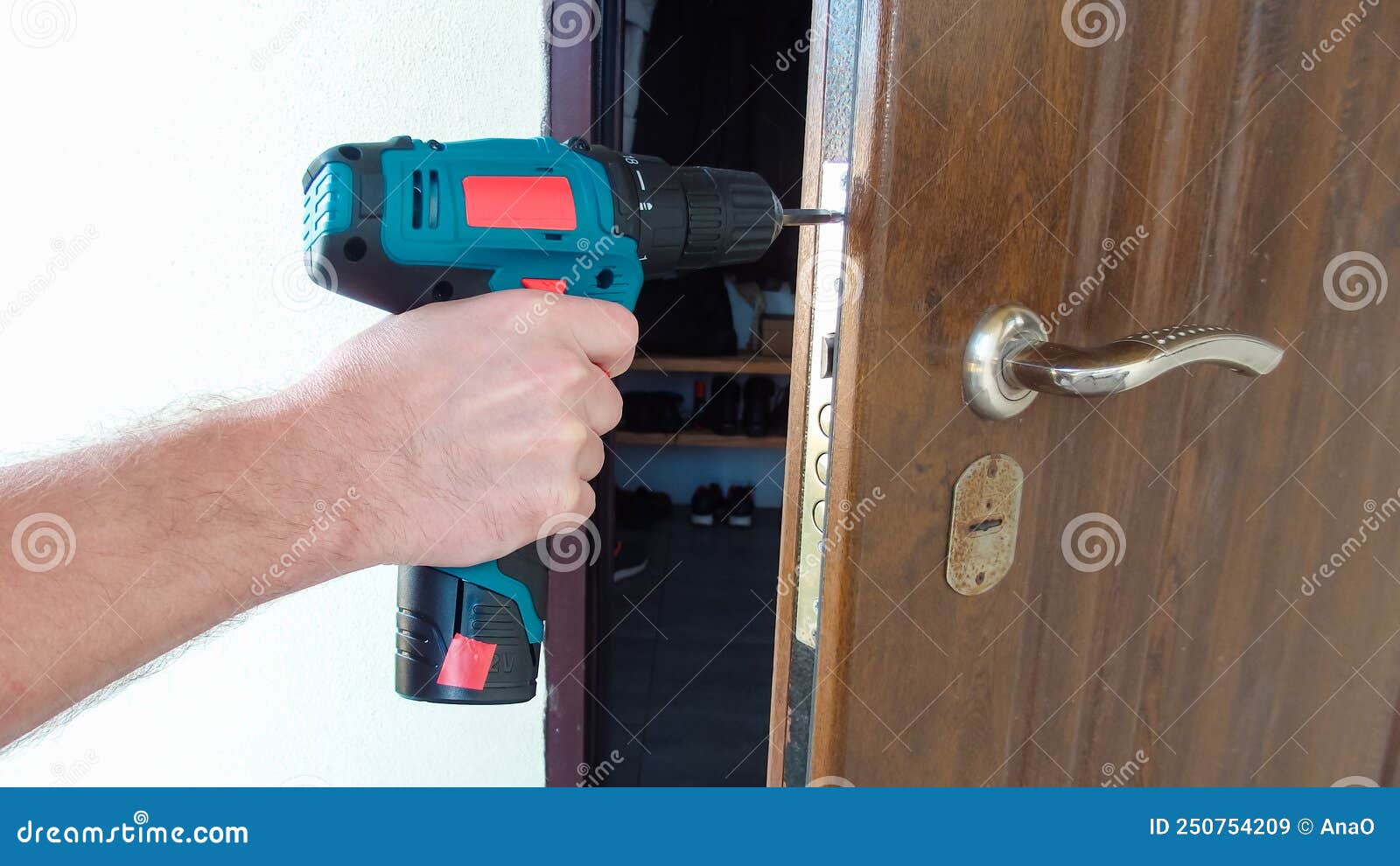 Hand S Man with Screwdriver. the Worker Installs a Door Lock in the ...