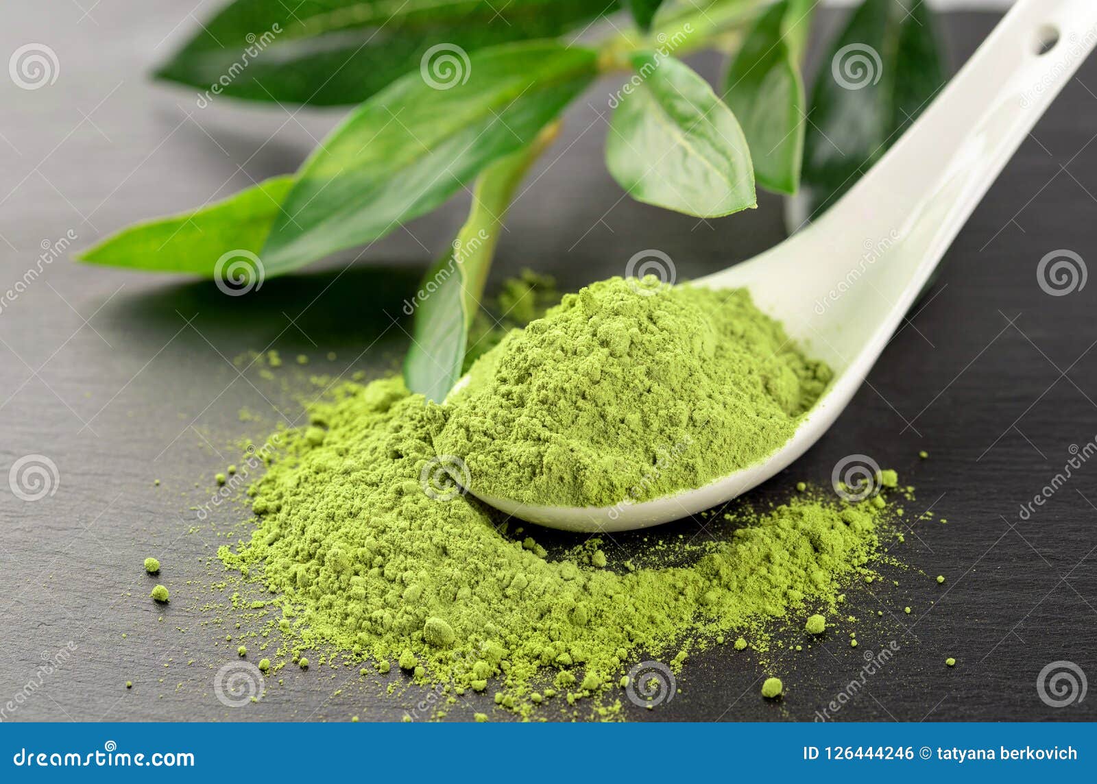 Matcha Powder in White Ceramic Spoon and Tea Leaves on Black Background ...