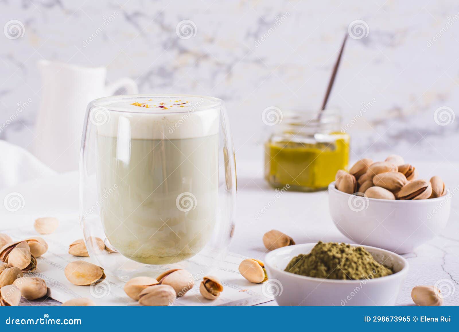 Matcha Tea with Pistachio Spread in a Glass and Nuts on the Table Stock ...