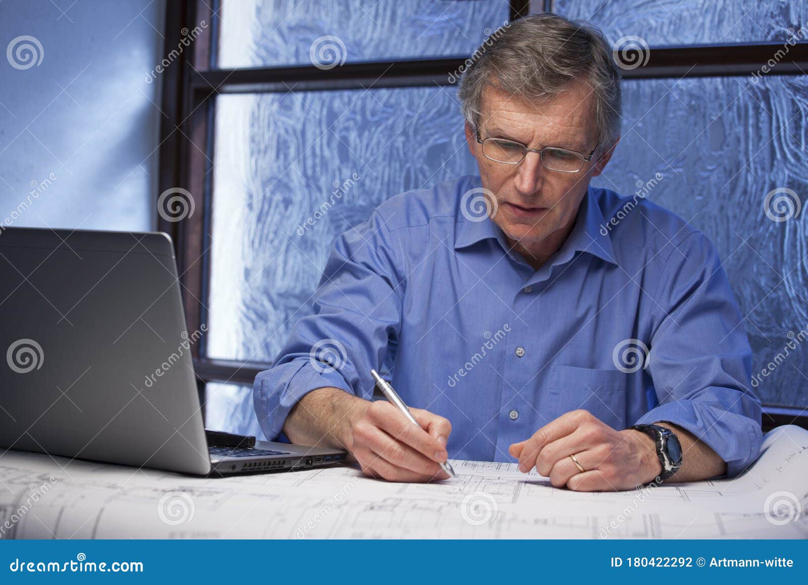 Mature Architect or Engineer Working from Home at a Desk with Laptop an ...