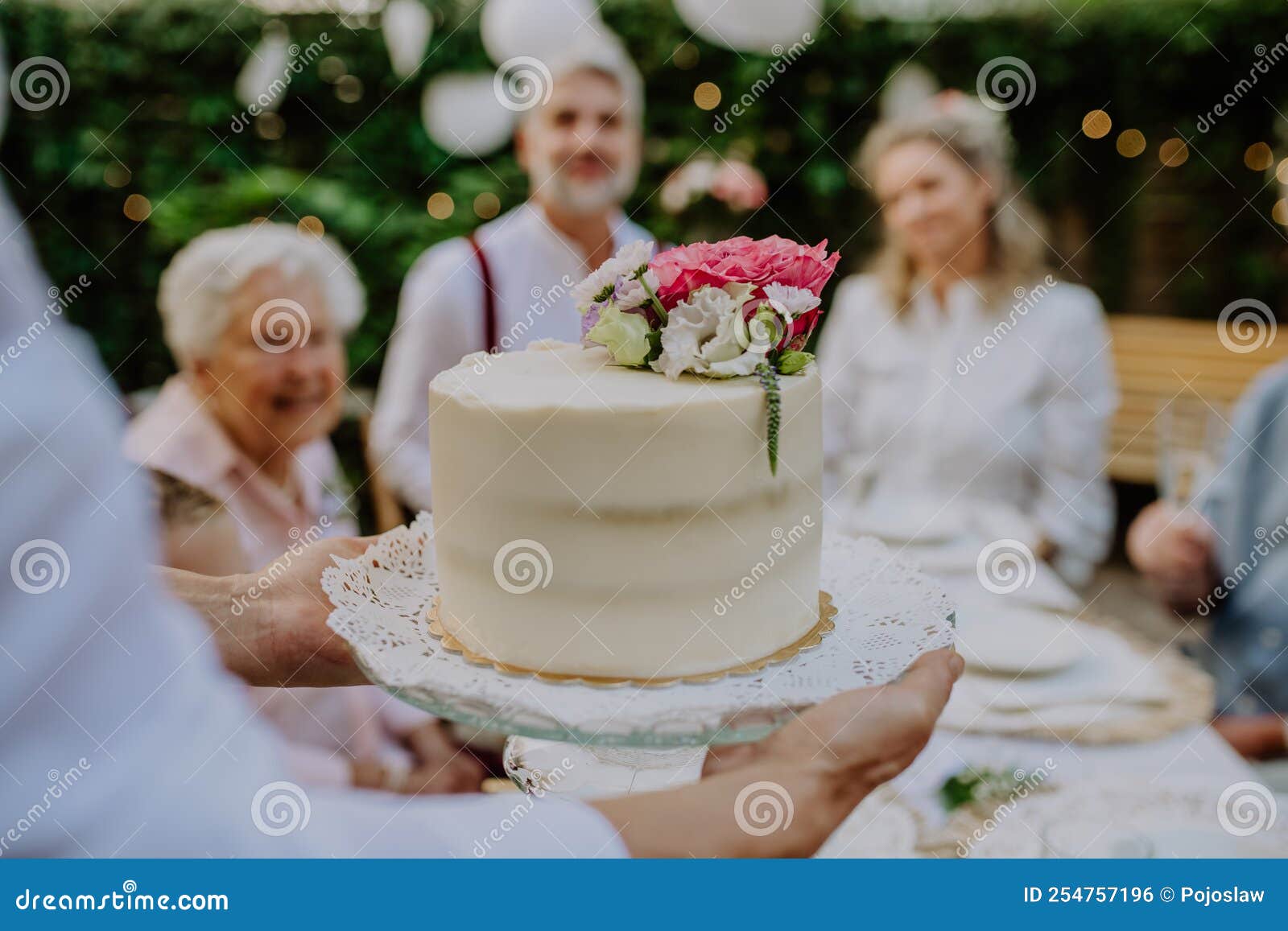 Mature Bride and Groom Getting a Cake at Wedding Reception Outside in ...