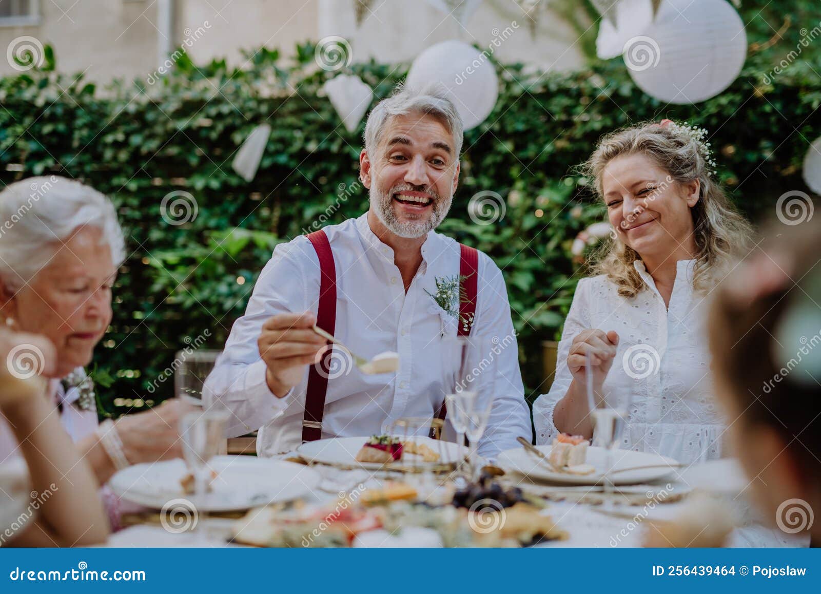 Mature Bride and Groom with Guests at Wedding Reception Outside in the ...