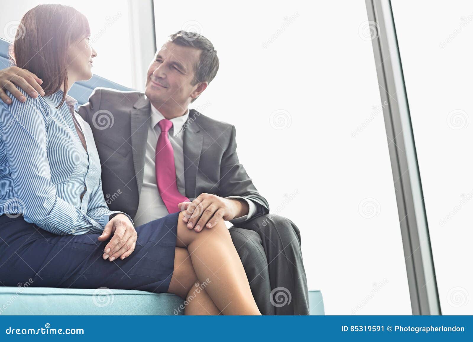 Mature Businessman Flirting With Female Colleague In Office Stock Image