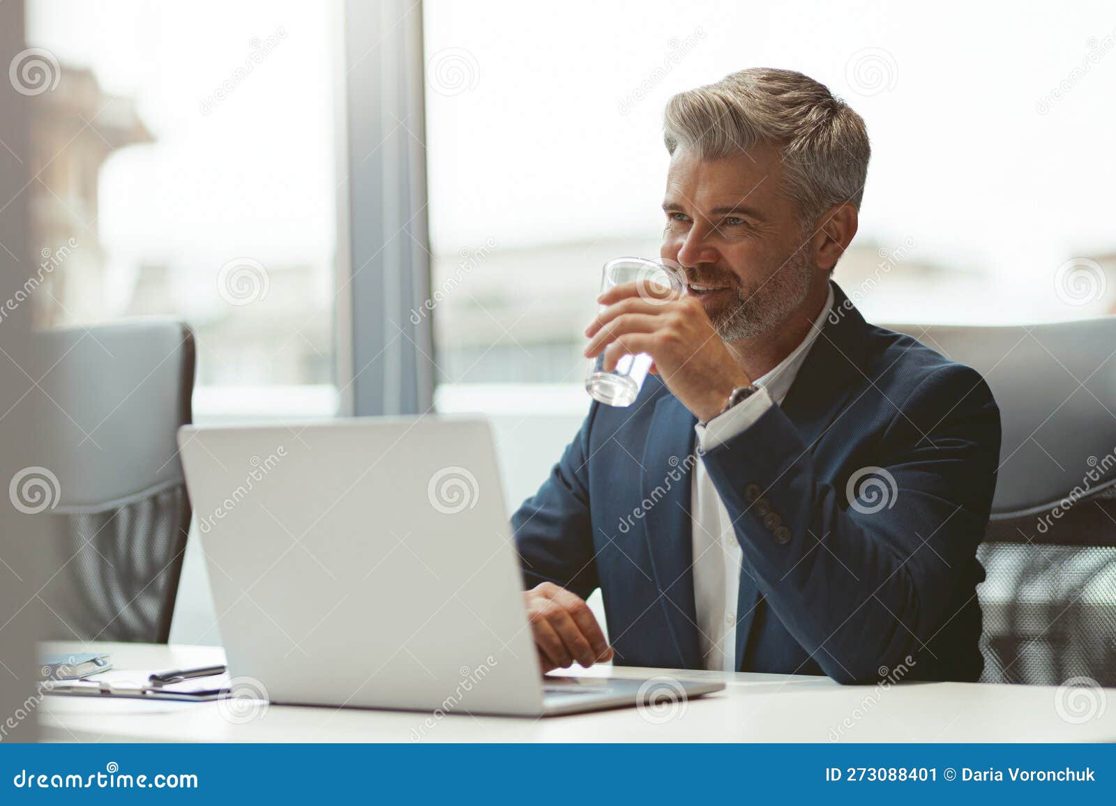 Mature Businessman Workingon Laptop and Drinking Water while Sitting in ... Mature Businessman Workingon Laptop and Drinking Water while Sitting in ...