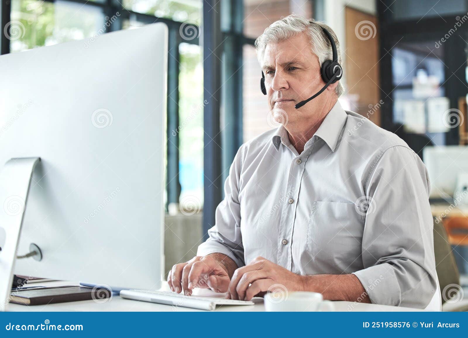 Focused on the Task at Hand. a Mature Call Centre Agent Sitting Alone ...