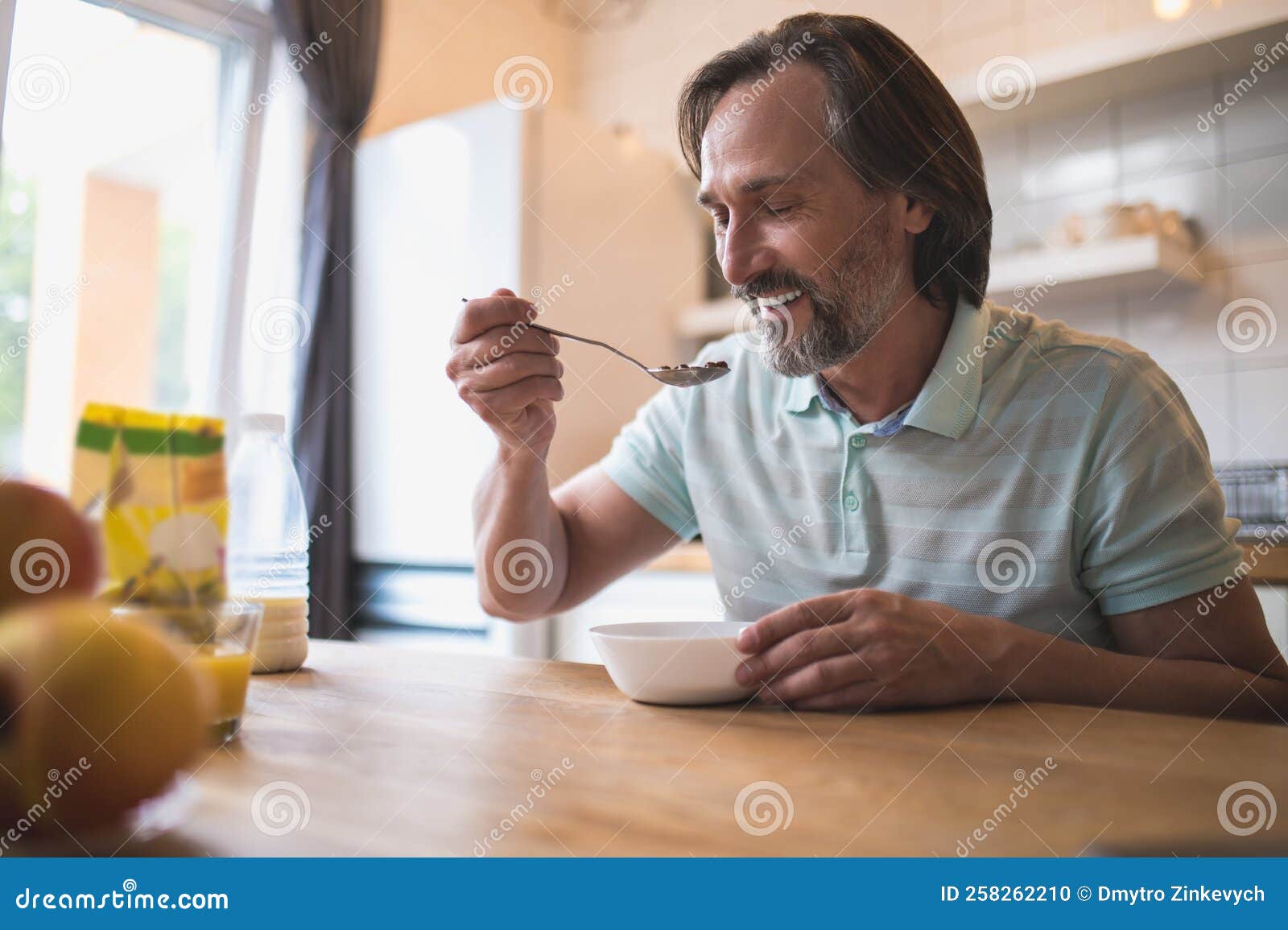 Mature Caucasian Man Sitting at the Table and Eating Breakfast Stock ...