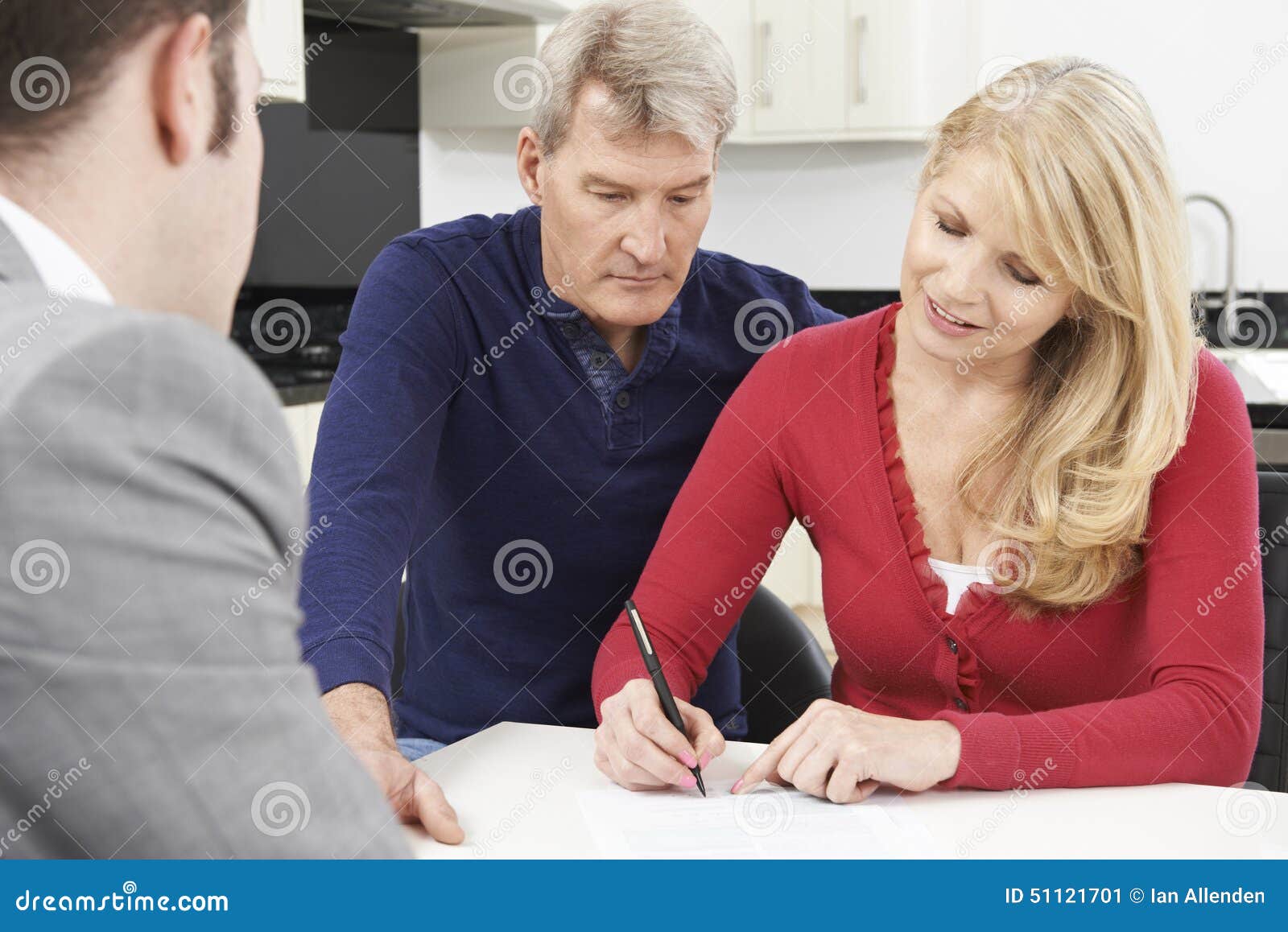 Mature Couple with Financial Advisor Signing Document at Home Stock ...