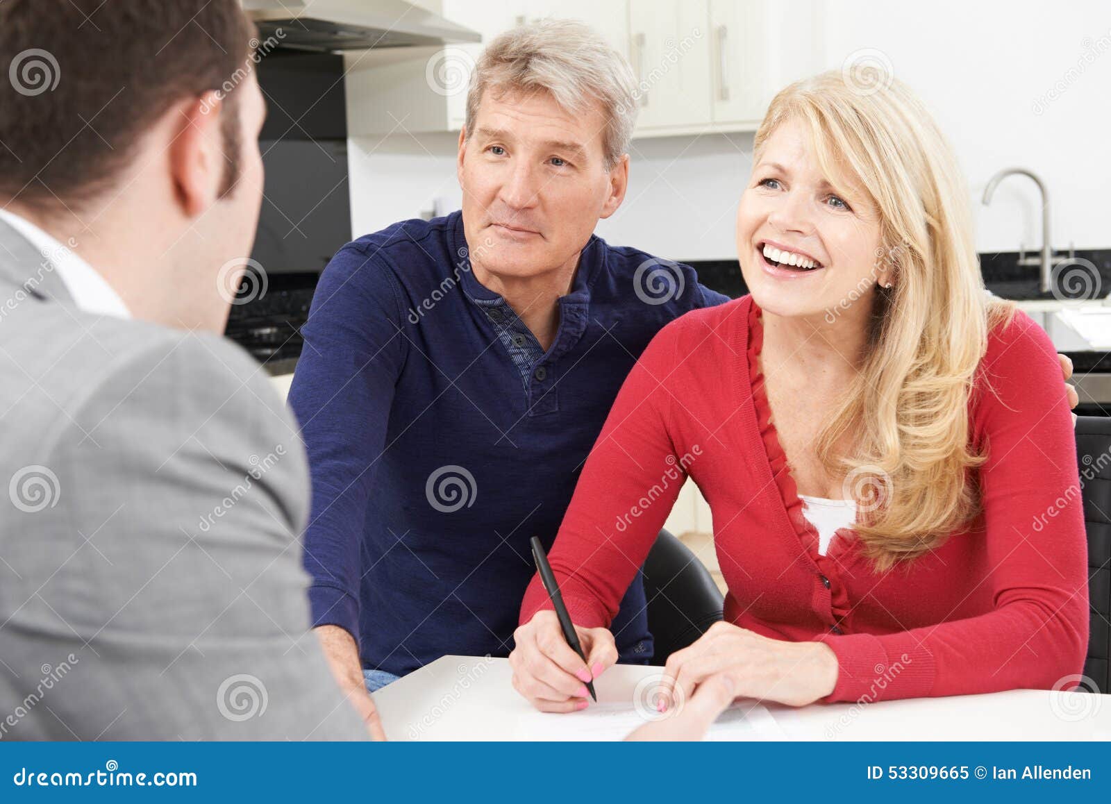 Mature Couple with Financial Advisor Signing Document at Home Stock ...