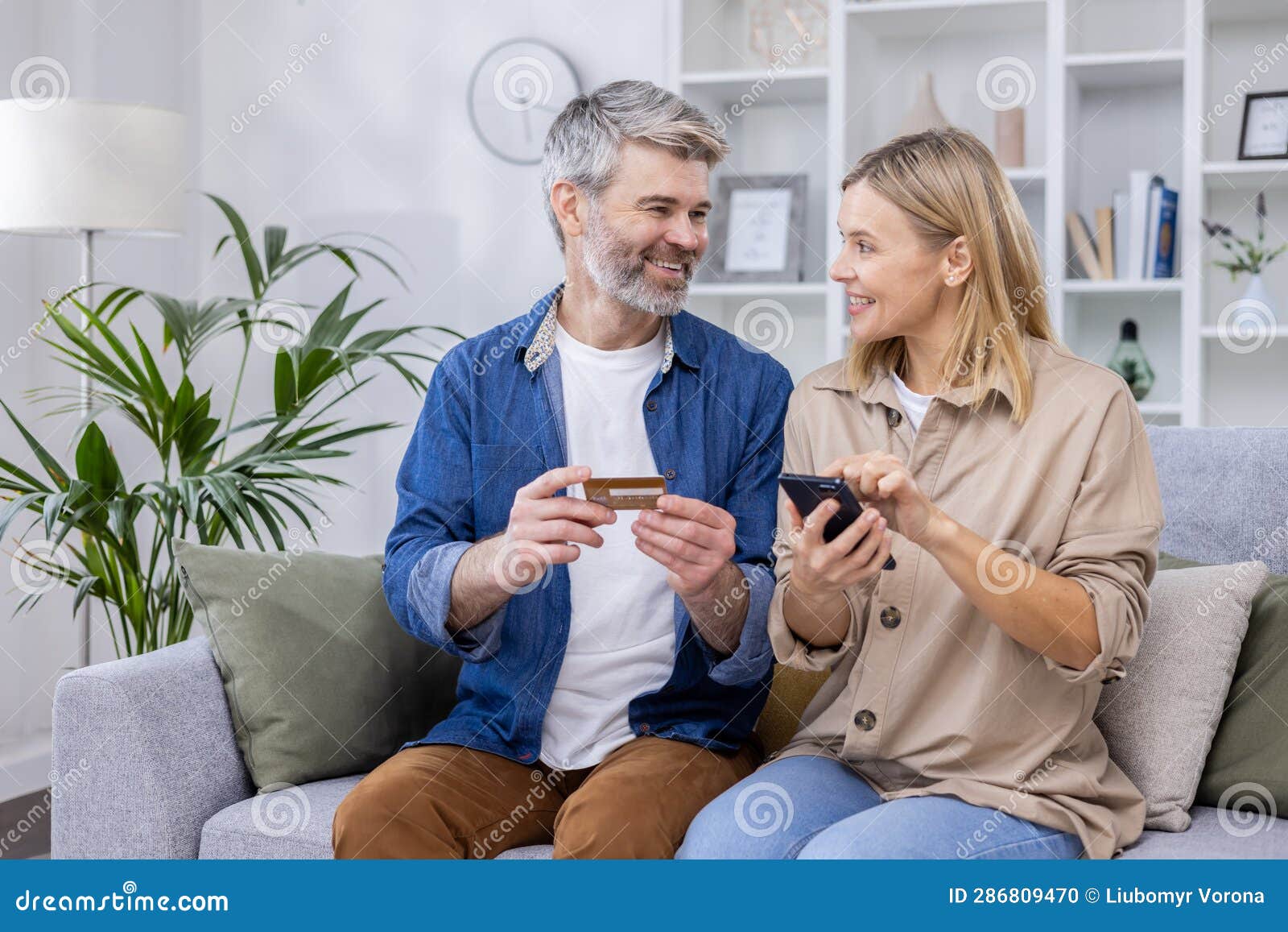Mature Couple Man And Woman Sitting Together On Sofa In Living Room At