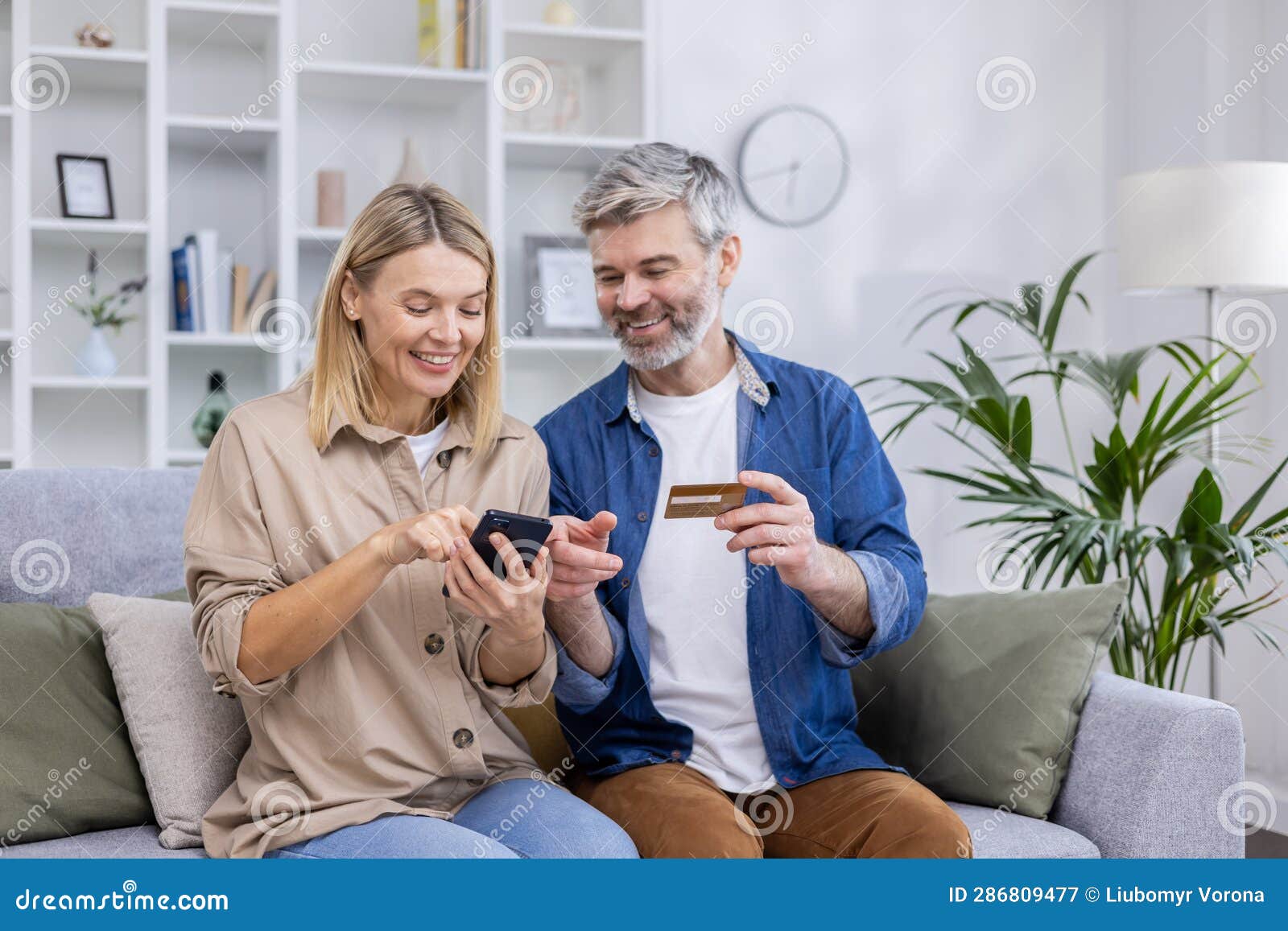 Mature Couple Man And Woman Sitting Together On Sofa In Living Room At