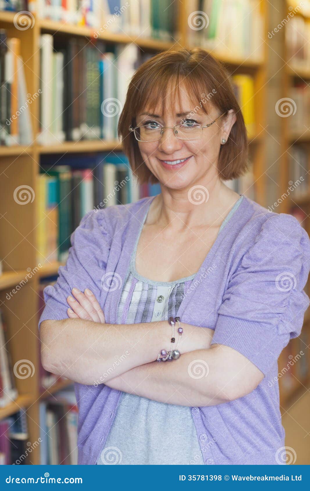Mature Female Librarian Posing in Library with Crossed Arms Stock Photo ...