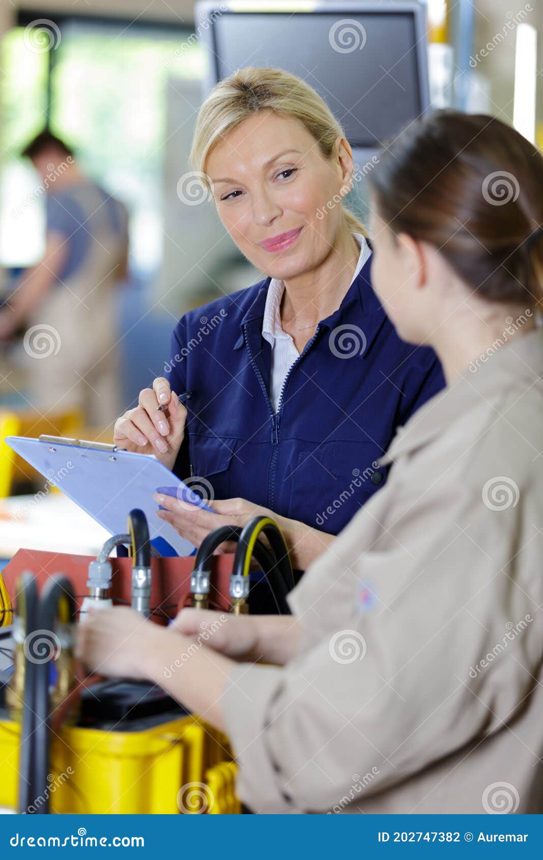 Mature Female Supervisor Encouraging Apprentice Technician with Smile ...