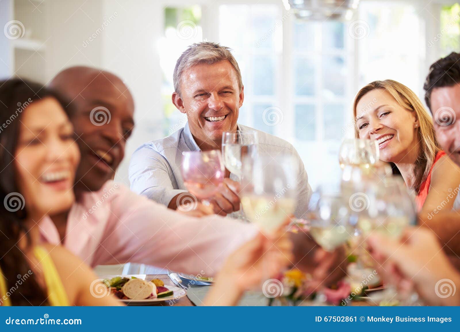 Mature Friends Sitting Around Table at Dinner Party Stock Image - Image ...