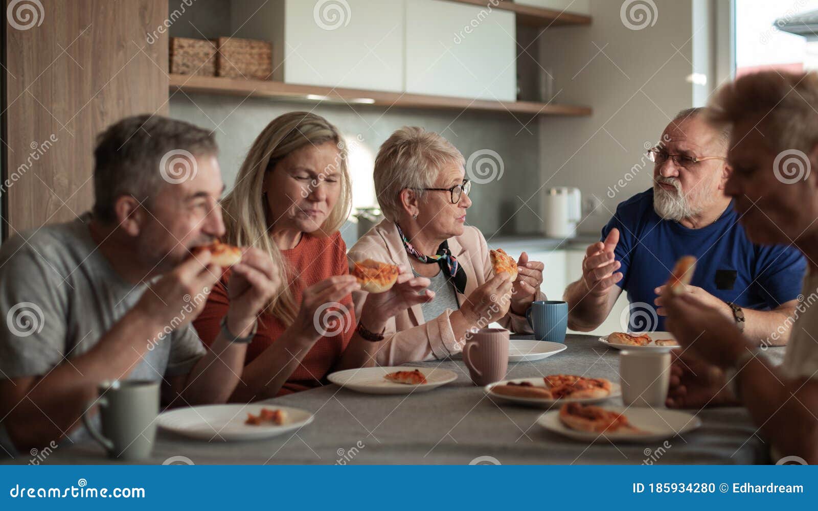 Mature Friends Sitting at the Table in the Home Kitchen. Stock Photo ...