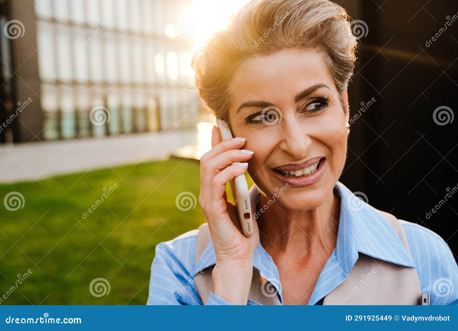 Mature Grey Woman Laughing While Talking On Mobile Phone Stock Image