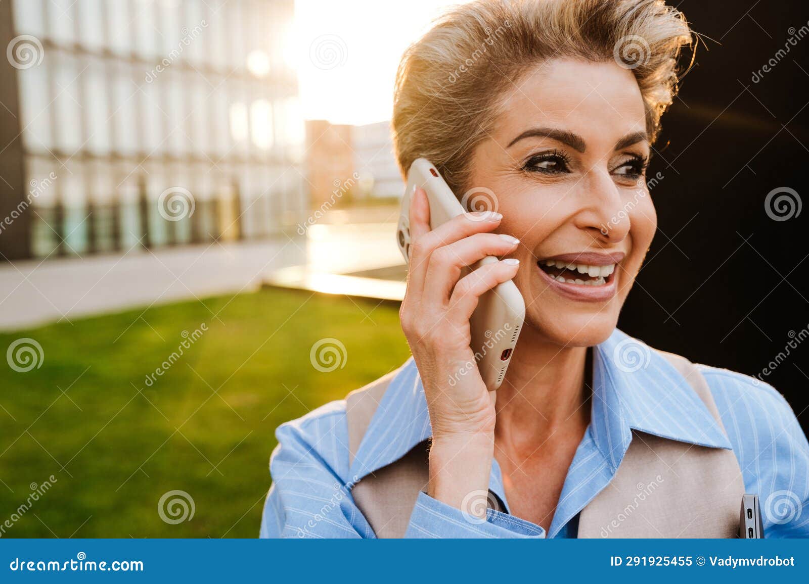 Mature Grey Woman Laughing While Talking On Mobile Phone Stock Image