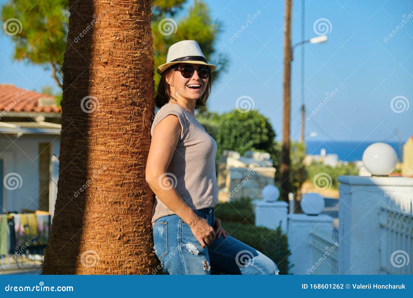 Mature Happy Beautiful Woman In Sunglasses Hat Standing Near Palm Tree