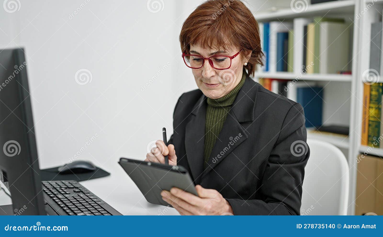 Mature Hispanic Woman Teacher Using Computer Taking Notes on Touchpad ...