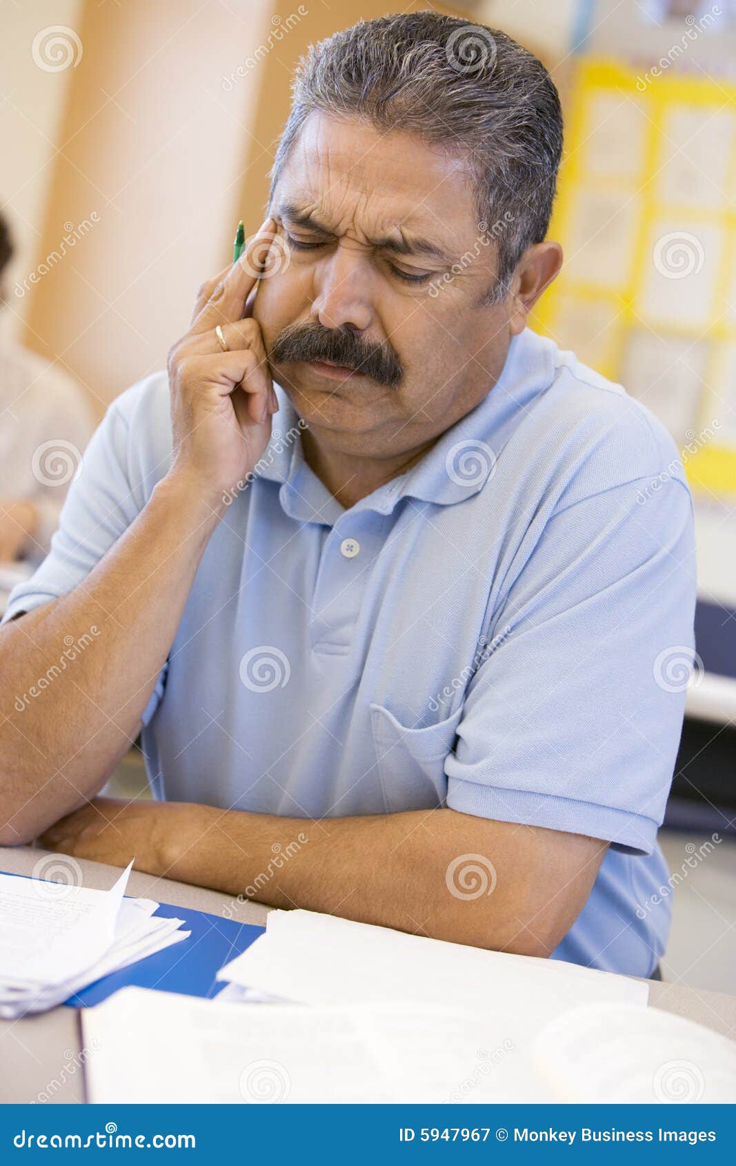 Mature Male Student Frowning in Class Stock Image - Image of desk ...