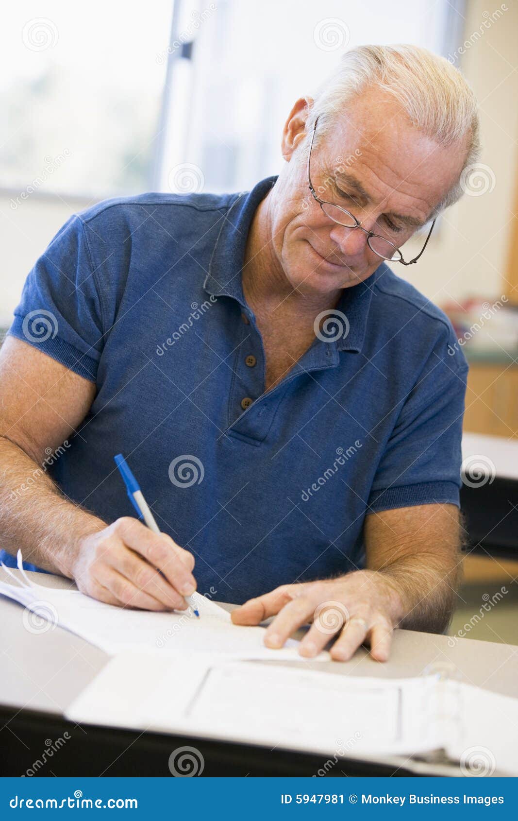 Mature Male Student Writing in Class Stock Image - Image of color ...