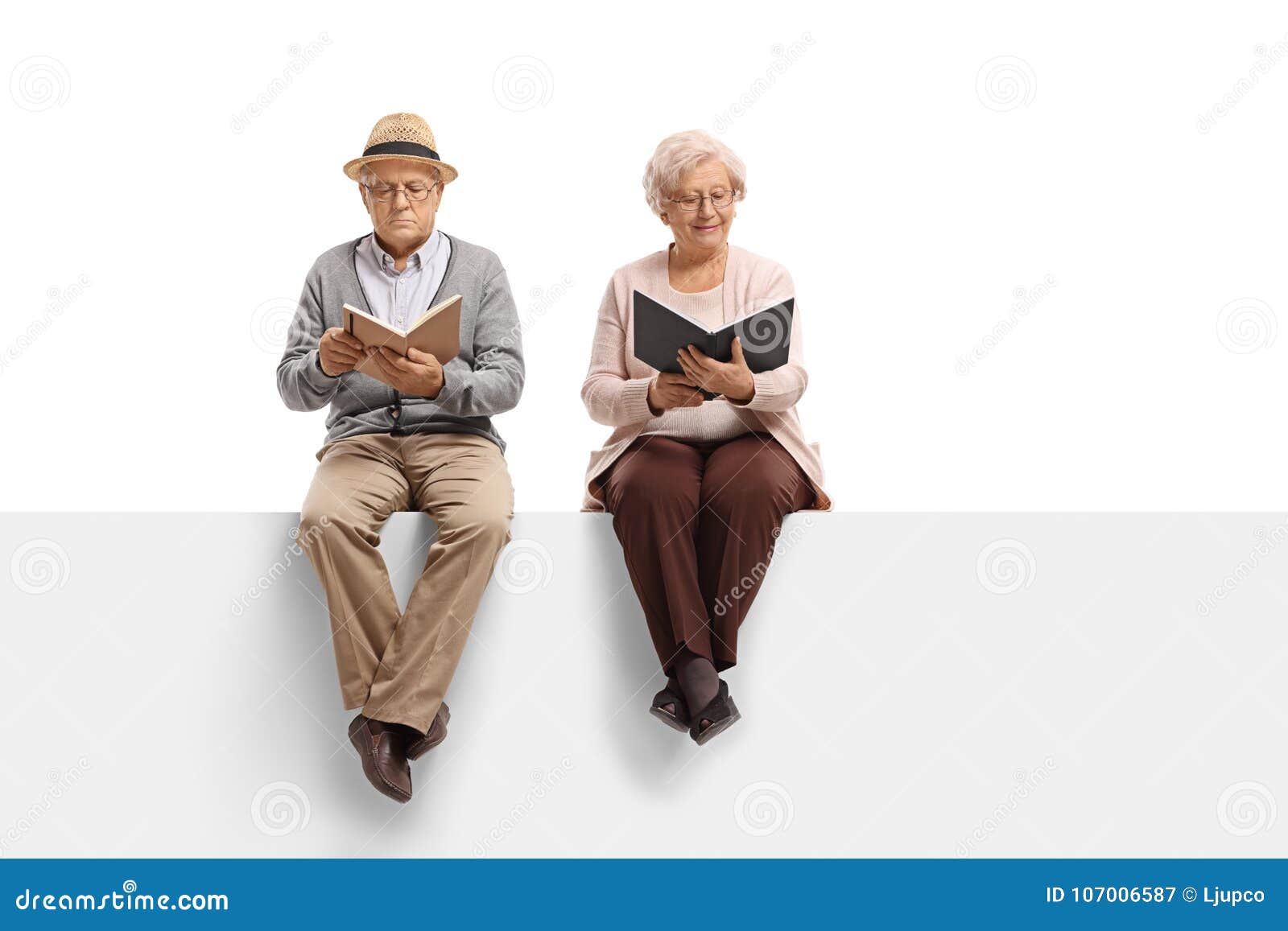 Mature Man And An Elderly Woman Sitting On A Panel And Reading B Stock