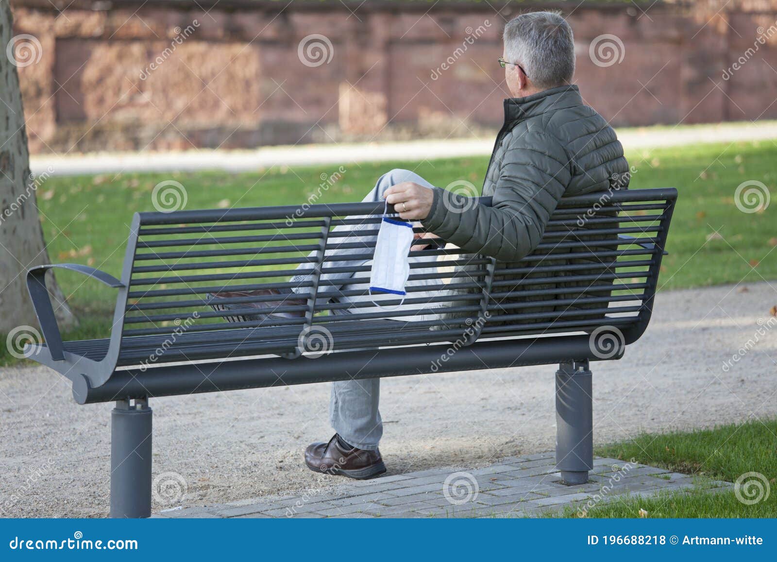 Mature Man with Face Mask in His Hand Sitting on a Park Bench Stock ...