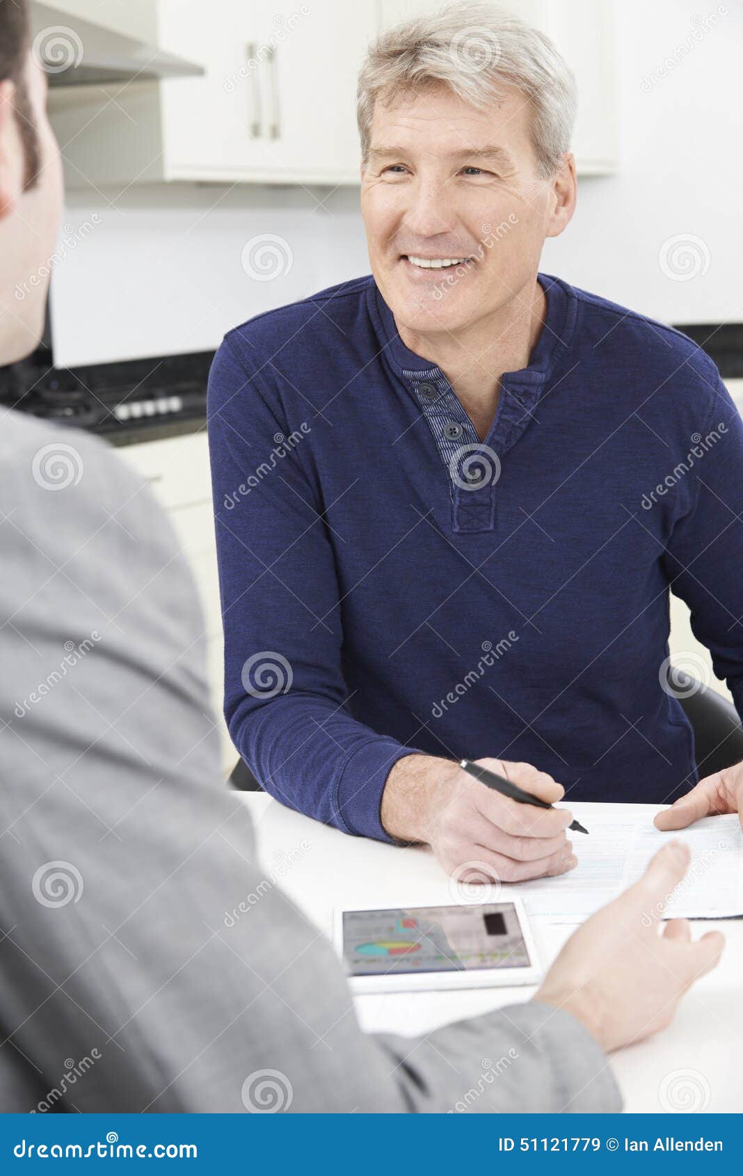 Mature Man with Financial Advisor Signing Document at Home Stock Image ...
