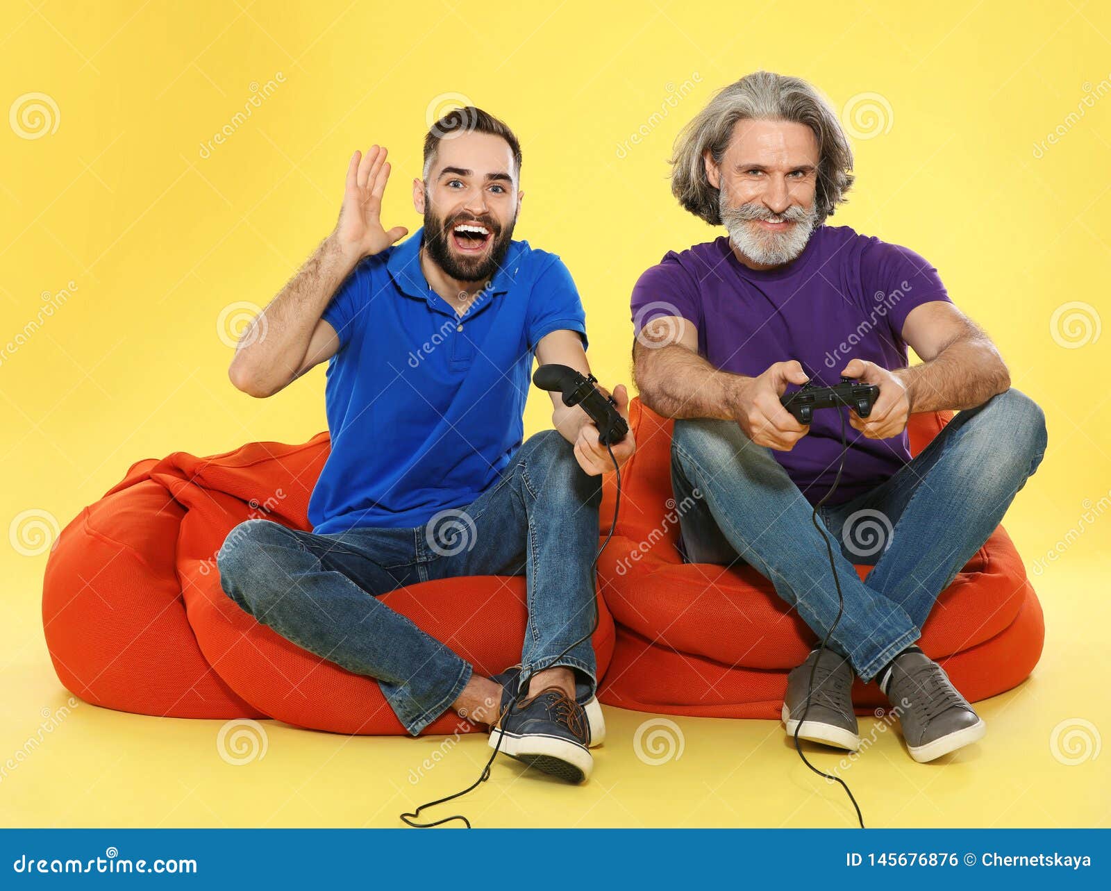 Mature Man and Guy Playing Video Games on Color Background Stock Photo ...