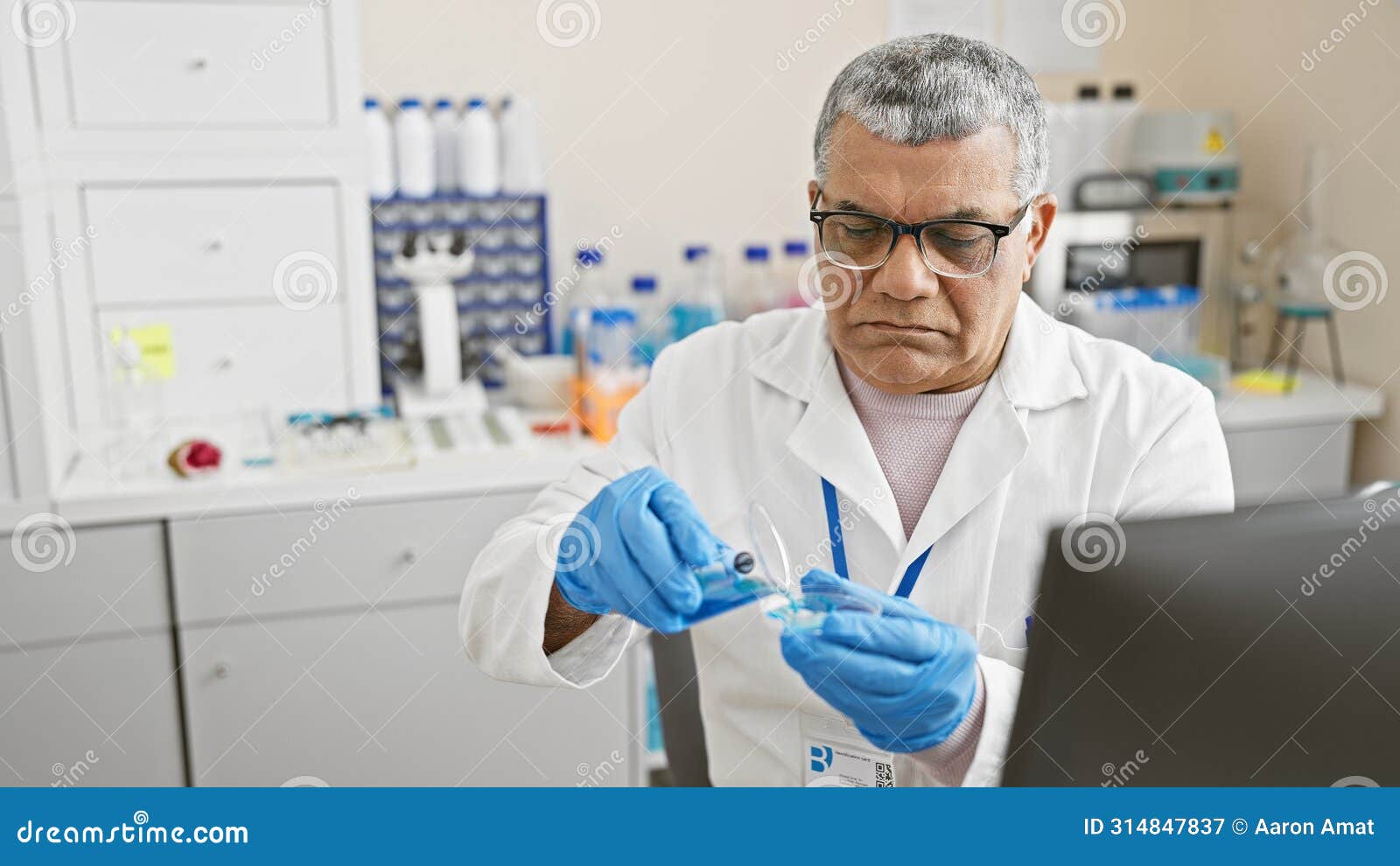 A Mature Man in a Lab Coat Conducts Experiments in a Well-equipped ...