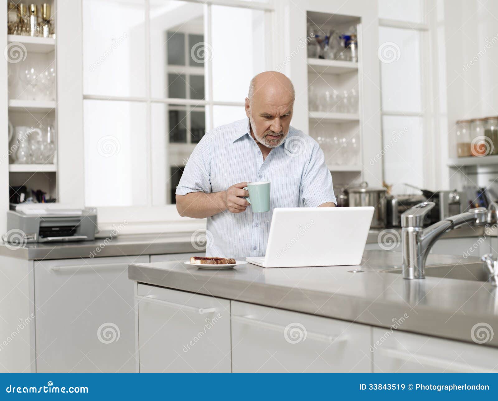 Mature Man with Laptop and Coffee Cup in Kitchen Stock Image - Image of ...