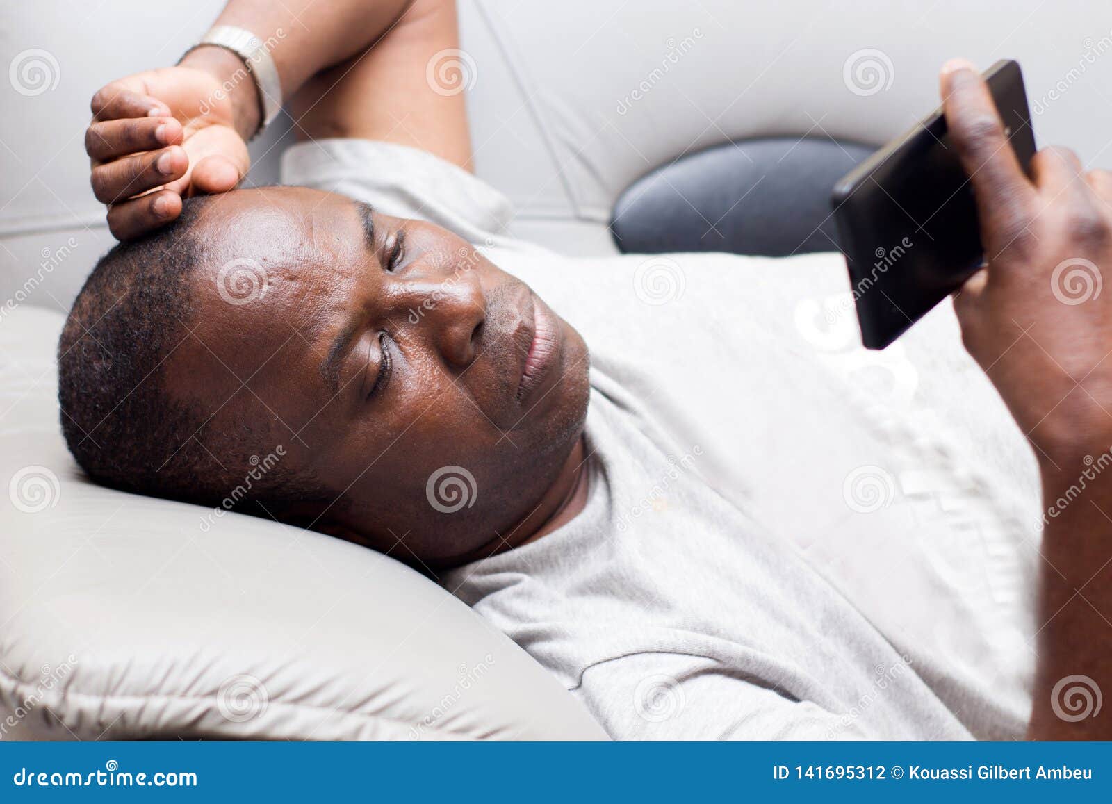 Man Using Mobile Phone Lying Down Stock Photo - Image of people, rest ...