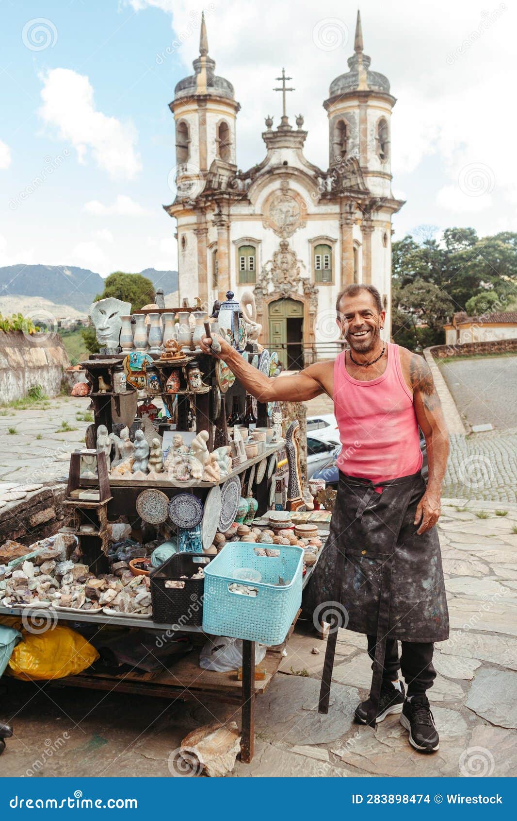 Mature Man Selling Various Antique Objects on an Outdoor Stand in Front ...
