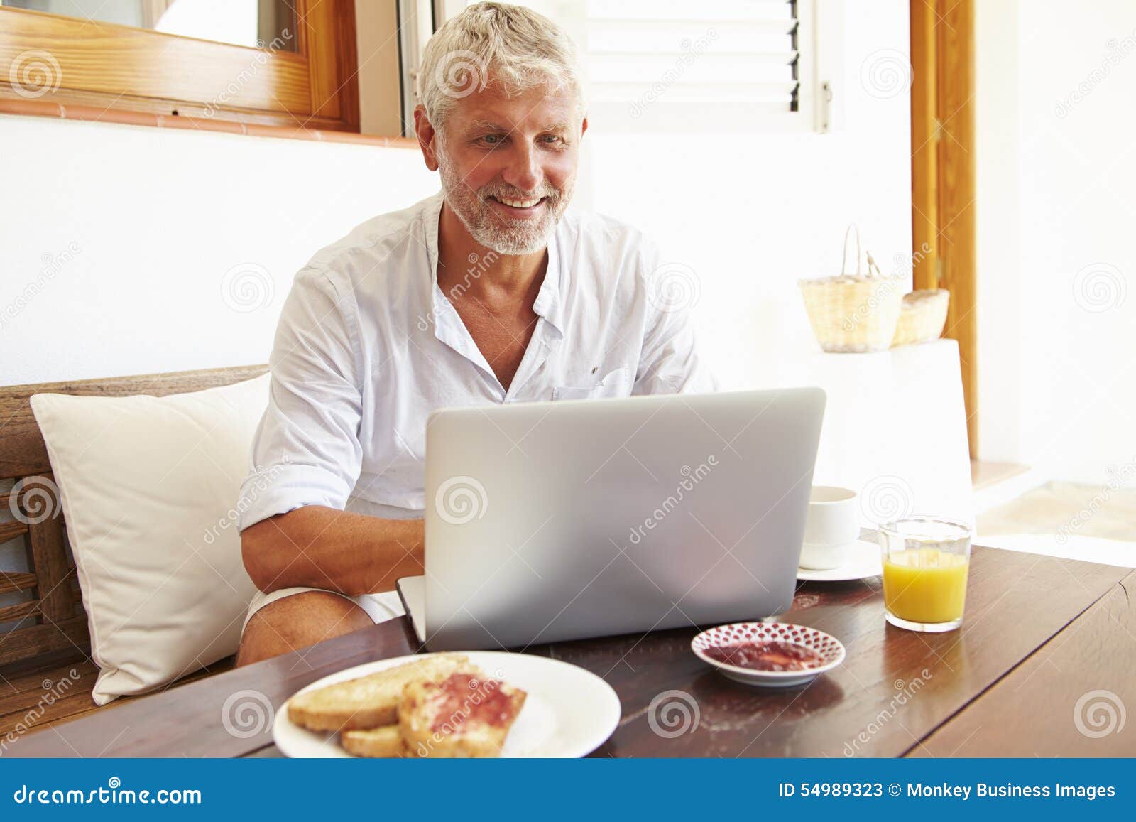 Mature Man Sitting at Breakfast Table Using Laptop Stock Image - Image ...