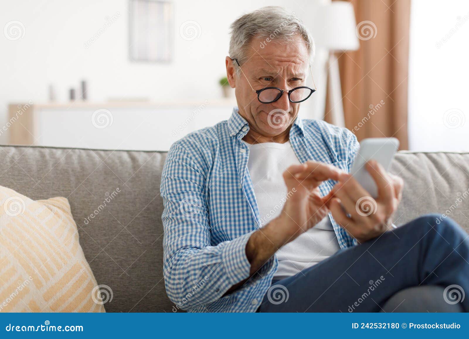 Mature Man Squinting Using Mobile Phone, Looking at Screen Stock Photo ...