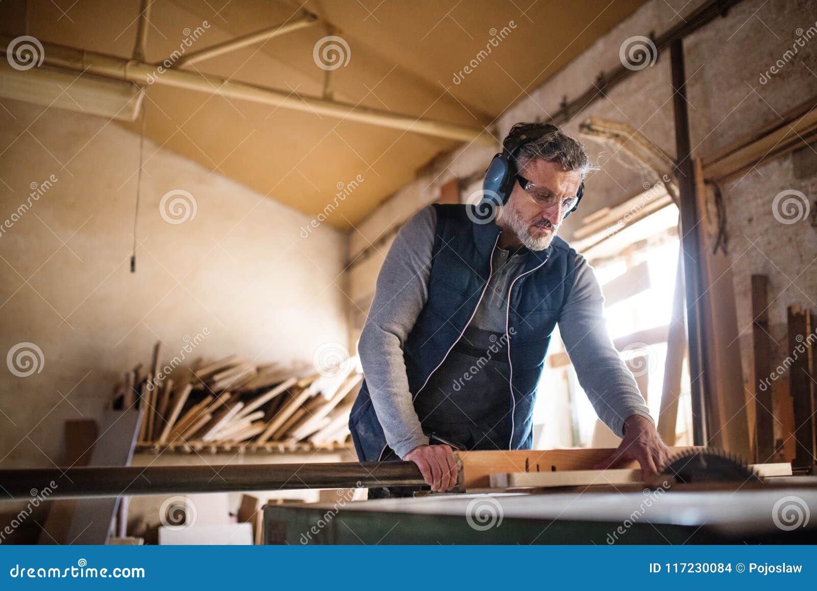A Man Worker in the Carpentry Workshop, Working with Wood. Stock Photo ...