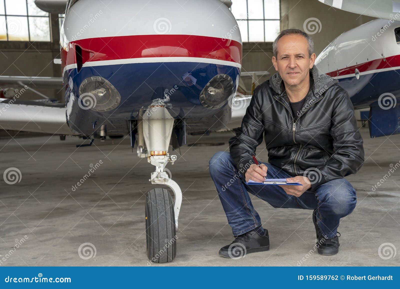 Mature Pilot in Front of Small Private Airplane in a Hangar Stock Photo ...