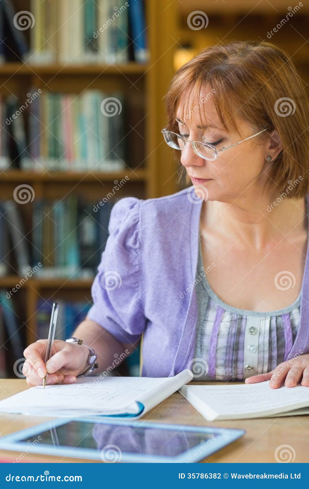Mature Student Writing Notes at Desk in the Library Stock Photo - Image ...